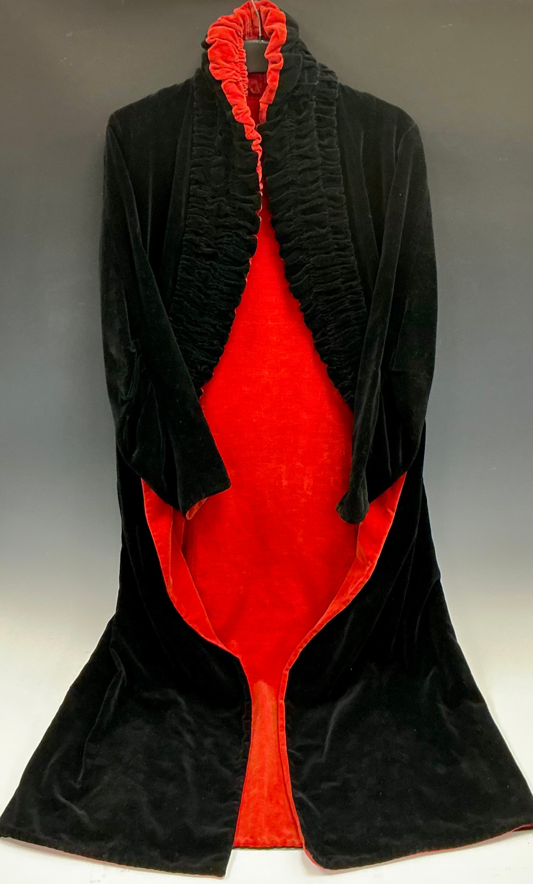 A 1920’s Velvet Opera Gown, in black, with a deep red interior, ruched ...