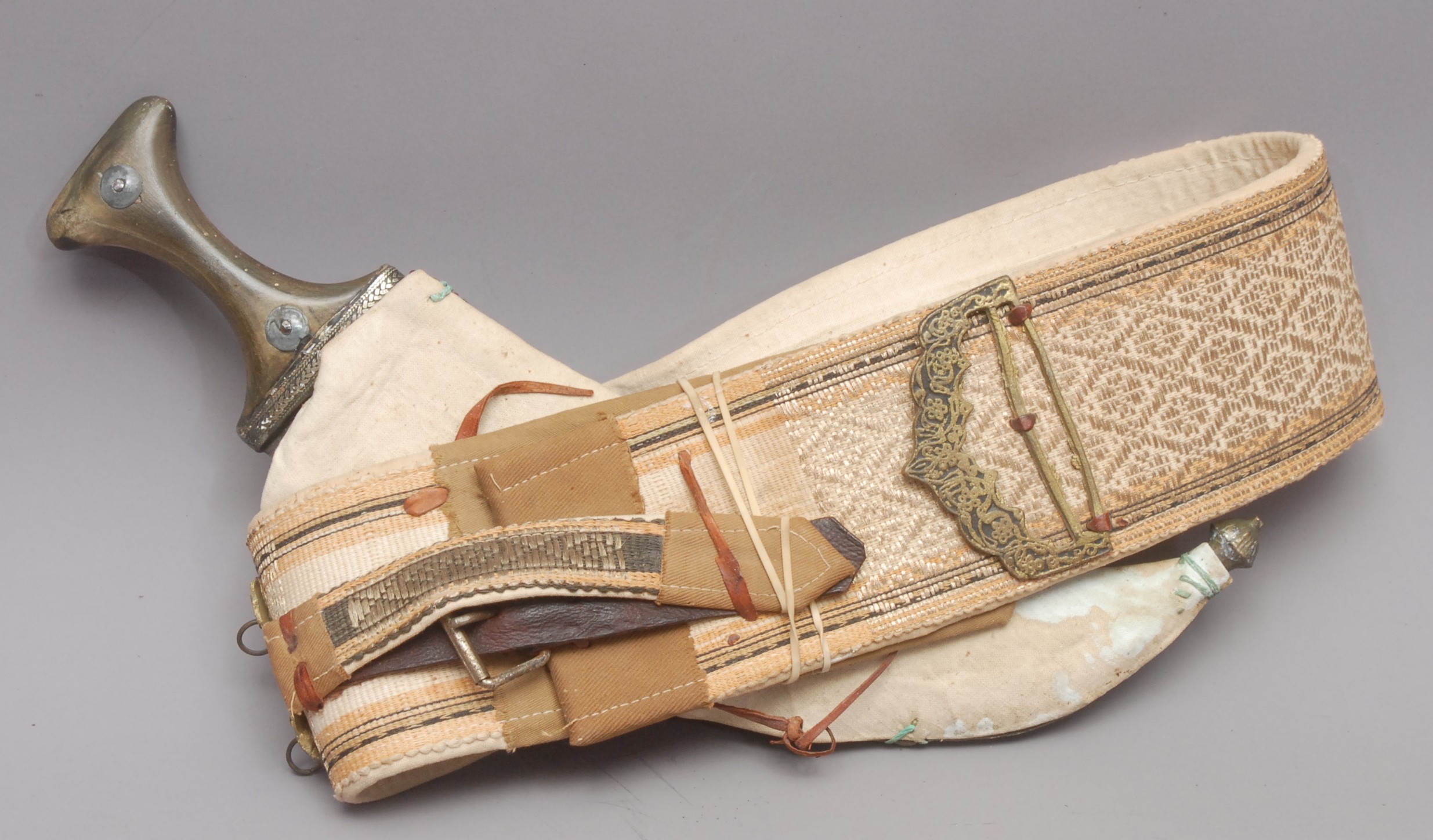 An Omani jambiya, 22cm curved blade, horn handle, brass mounted ...