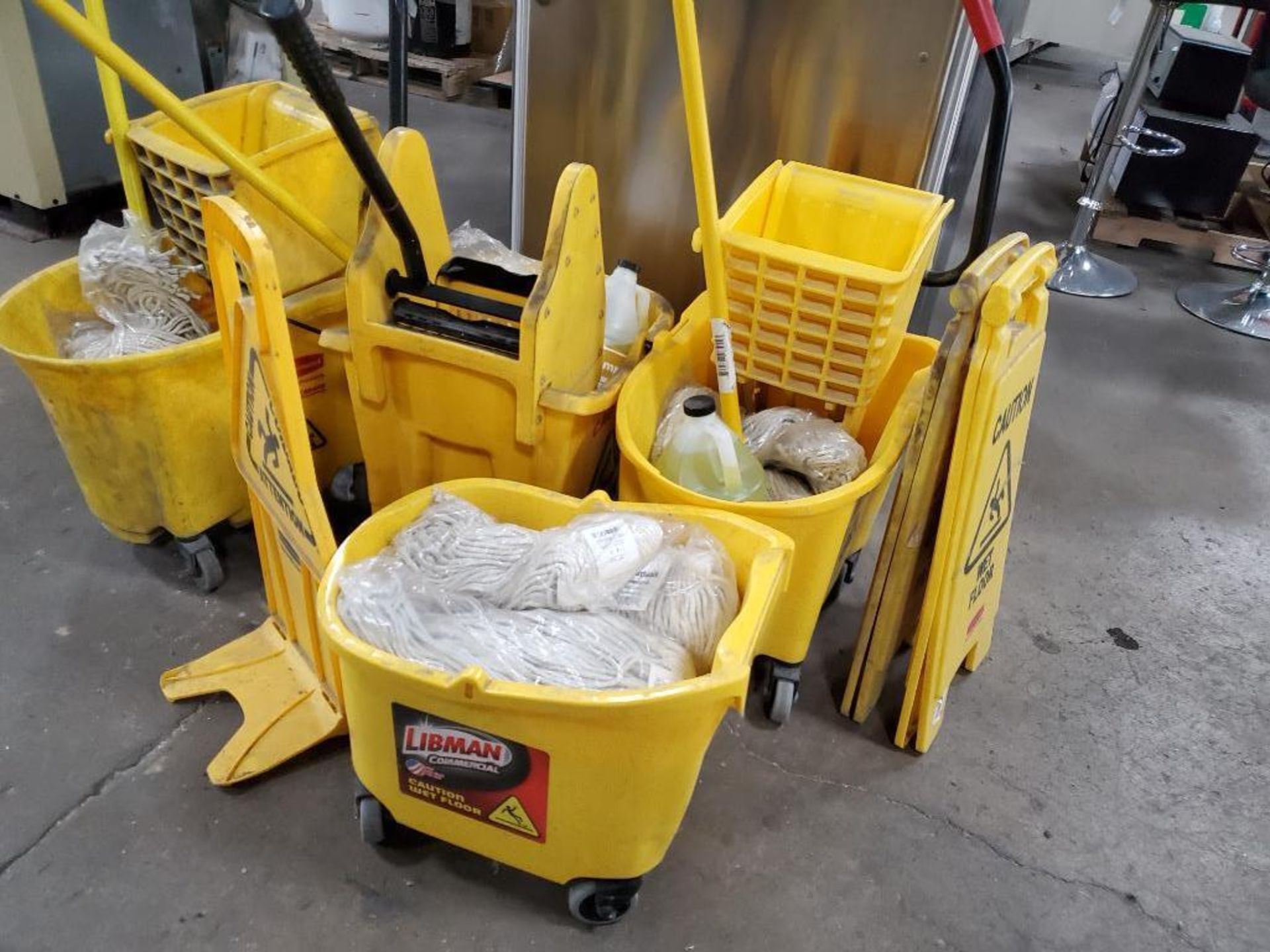 Assorted mop buckets and refrigerator.