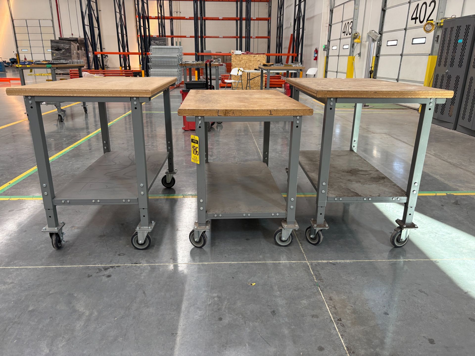 Lot of workbench , containing: 7 ULINE brand mobile work tables with 4 ...