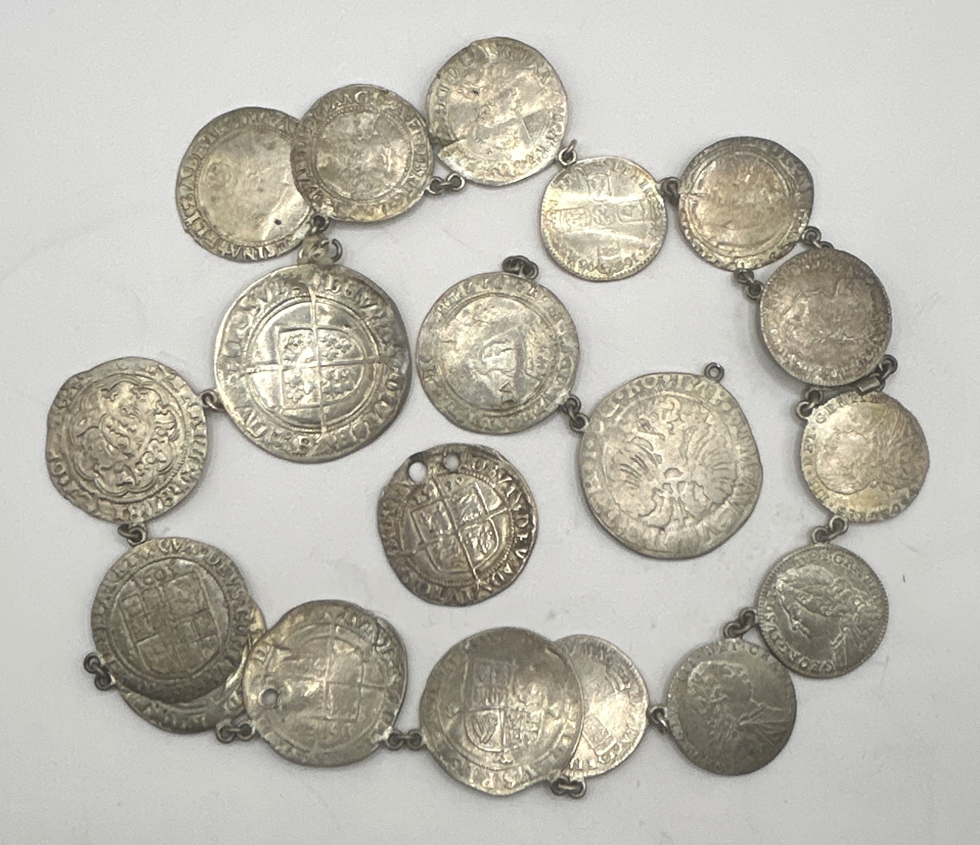 A group of hammered coins, regretfully made into a small chain, with ...
