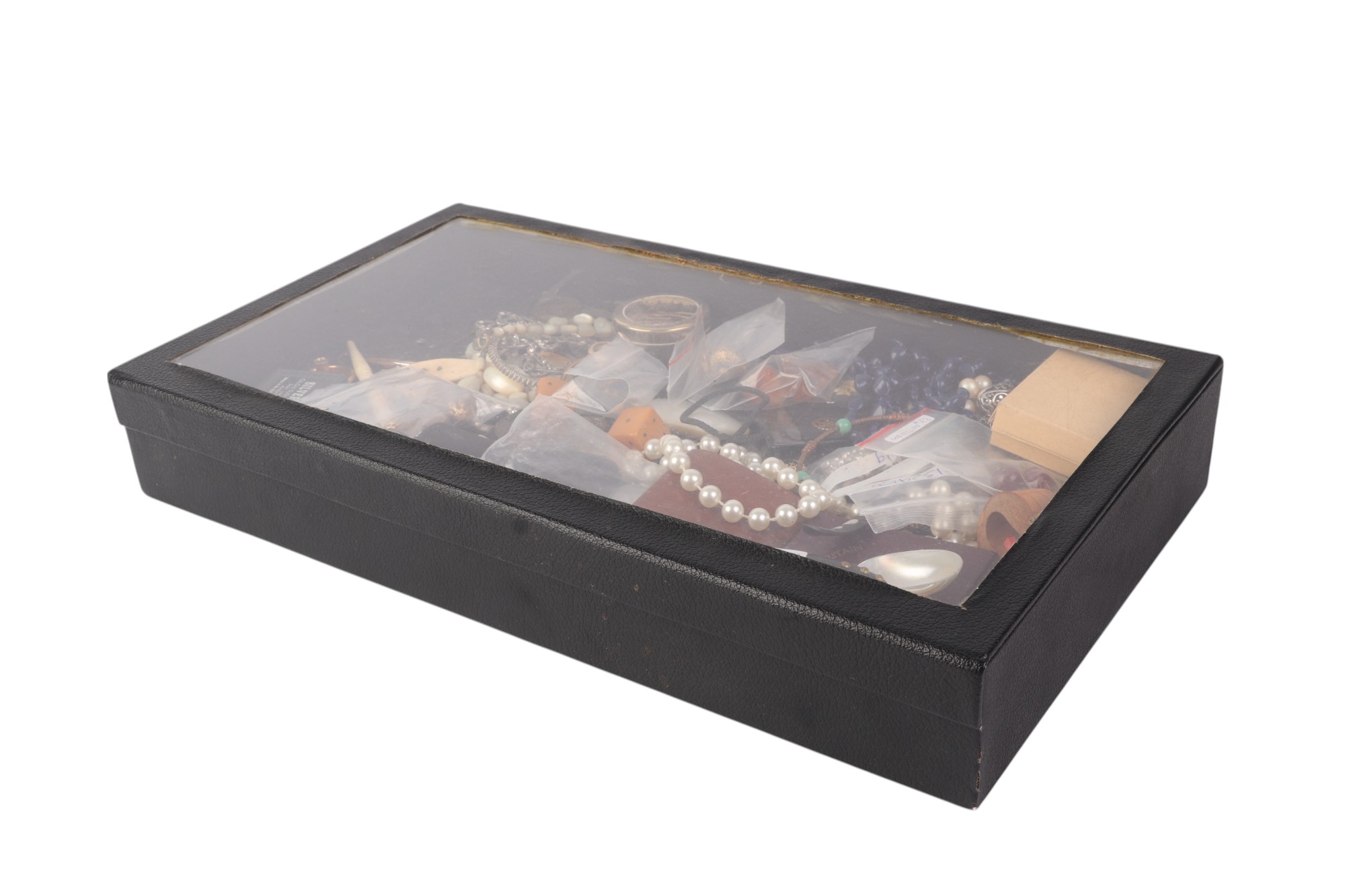 A tabletop display case containing vintage jewellery and collectables.