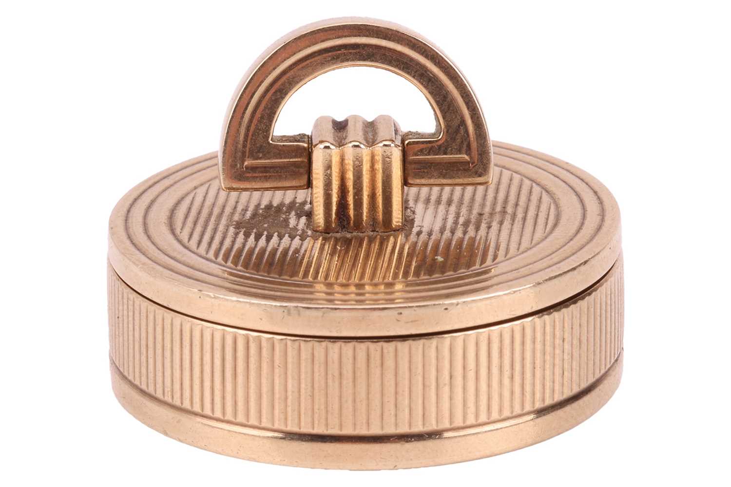 Cartier - a pill box in 9ct gold, of squat cylinder form in ribbed ...