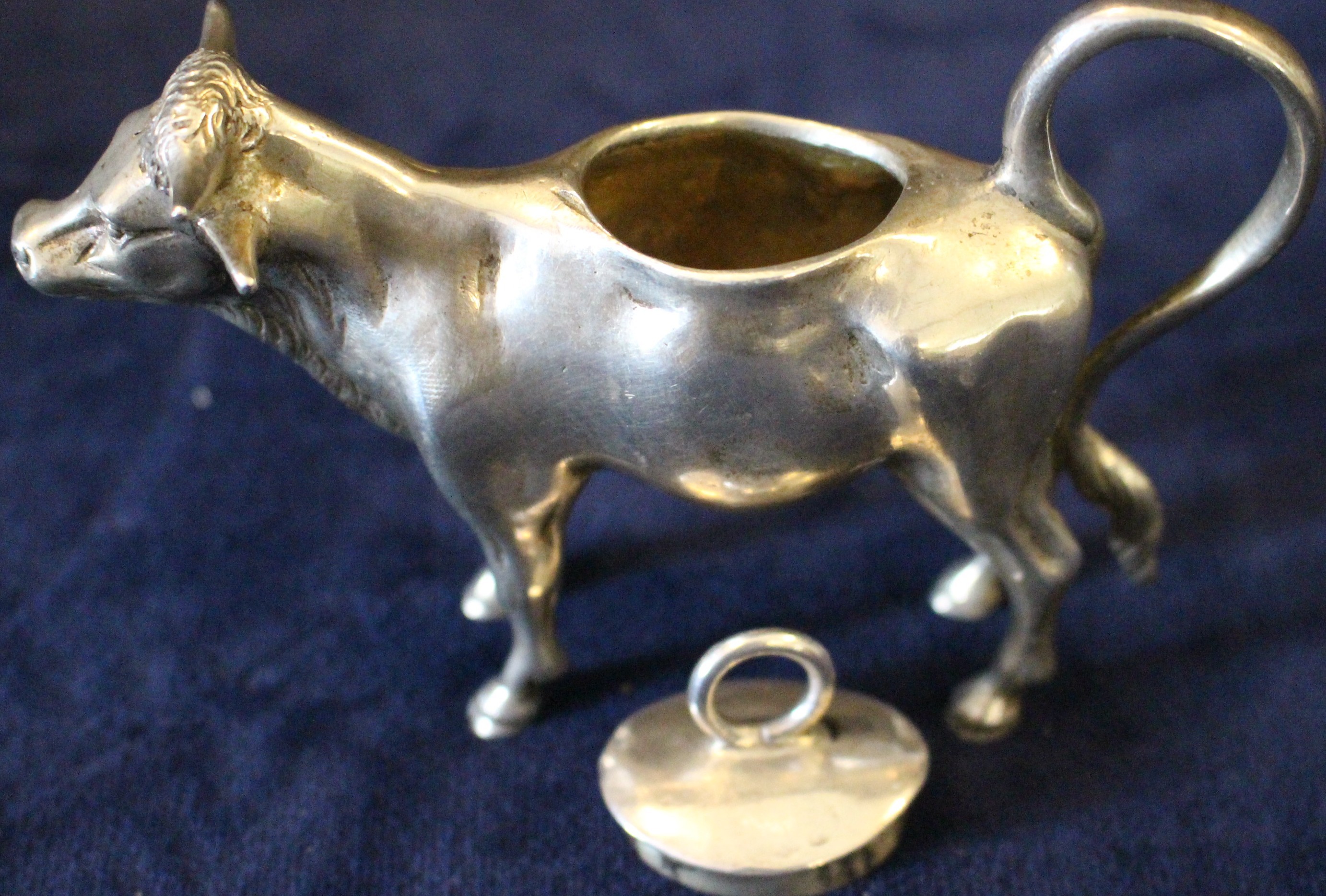 A German silver cow creamer and cover, the tail forming the handle ...
