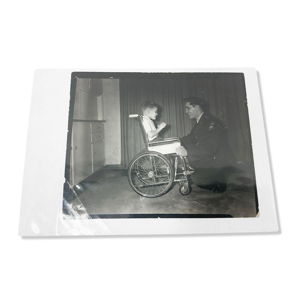 the black and white photograph showing Elvis in military uniform with a ...