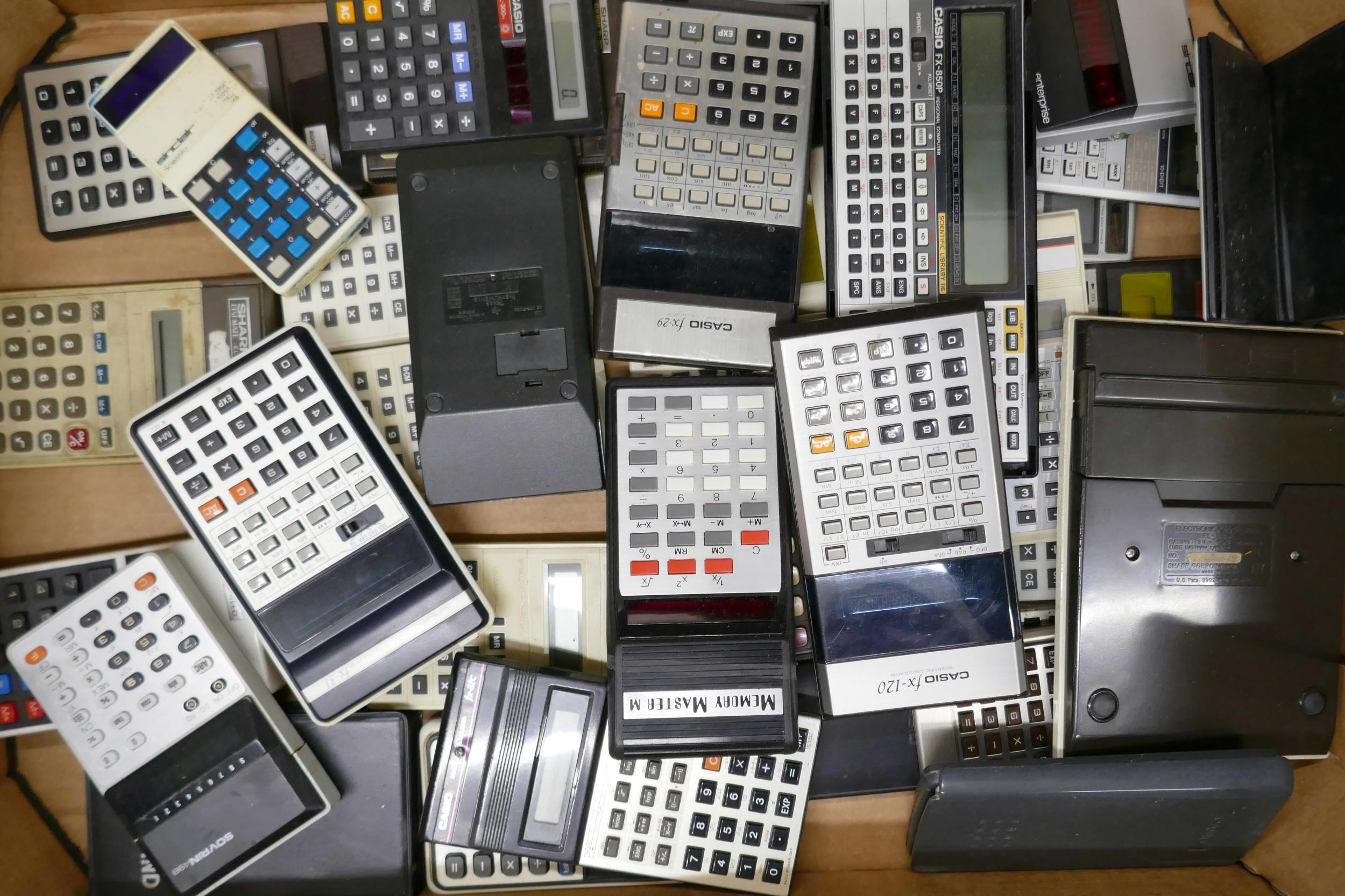A box of vintage calculators including Casio Scientific
