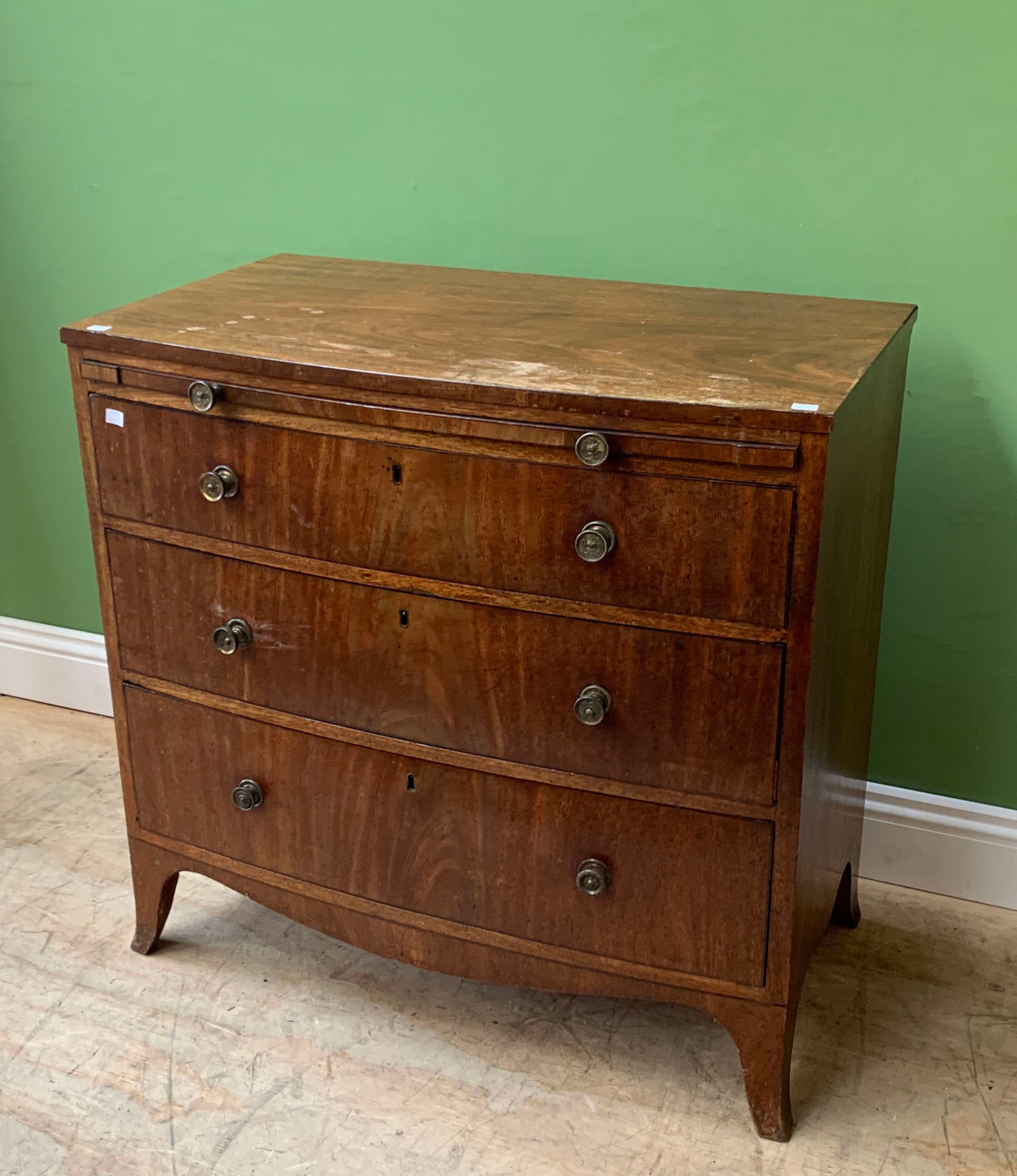 An early 19th century bowfront mahogany chest with a slide over three ...