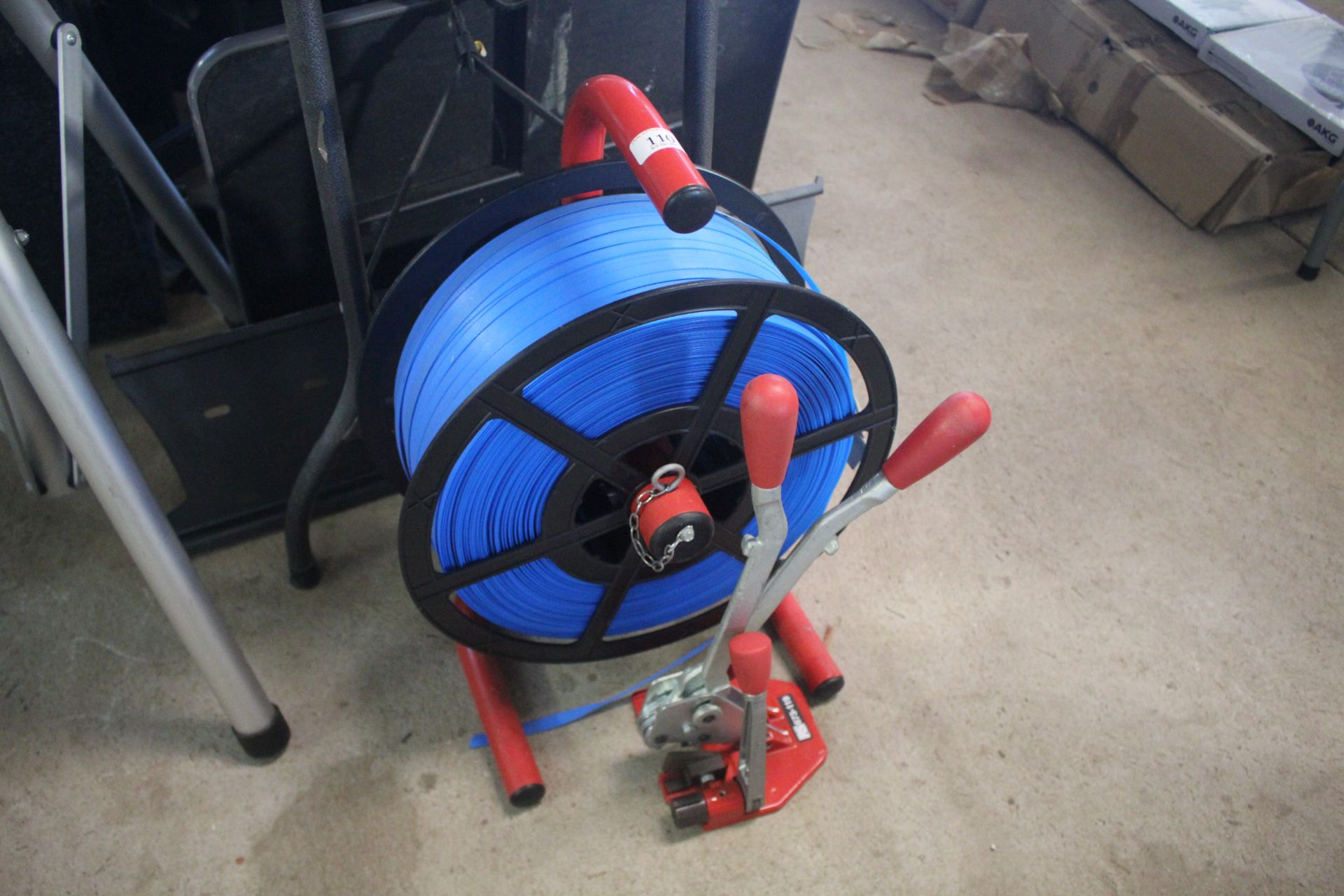 Reel of polypropylene strapping band and hand tensioner tool.