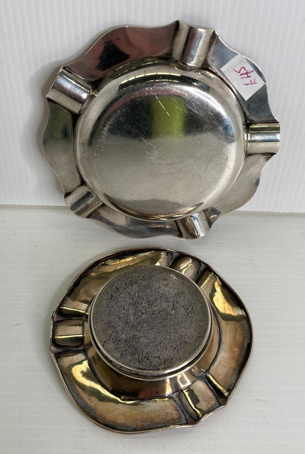 Two silver hallmark ashtrays; one stamped Birmingham 1920, and the ...