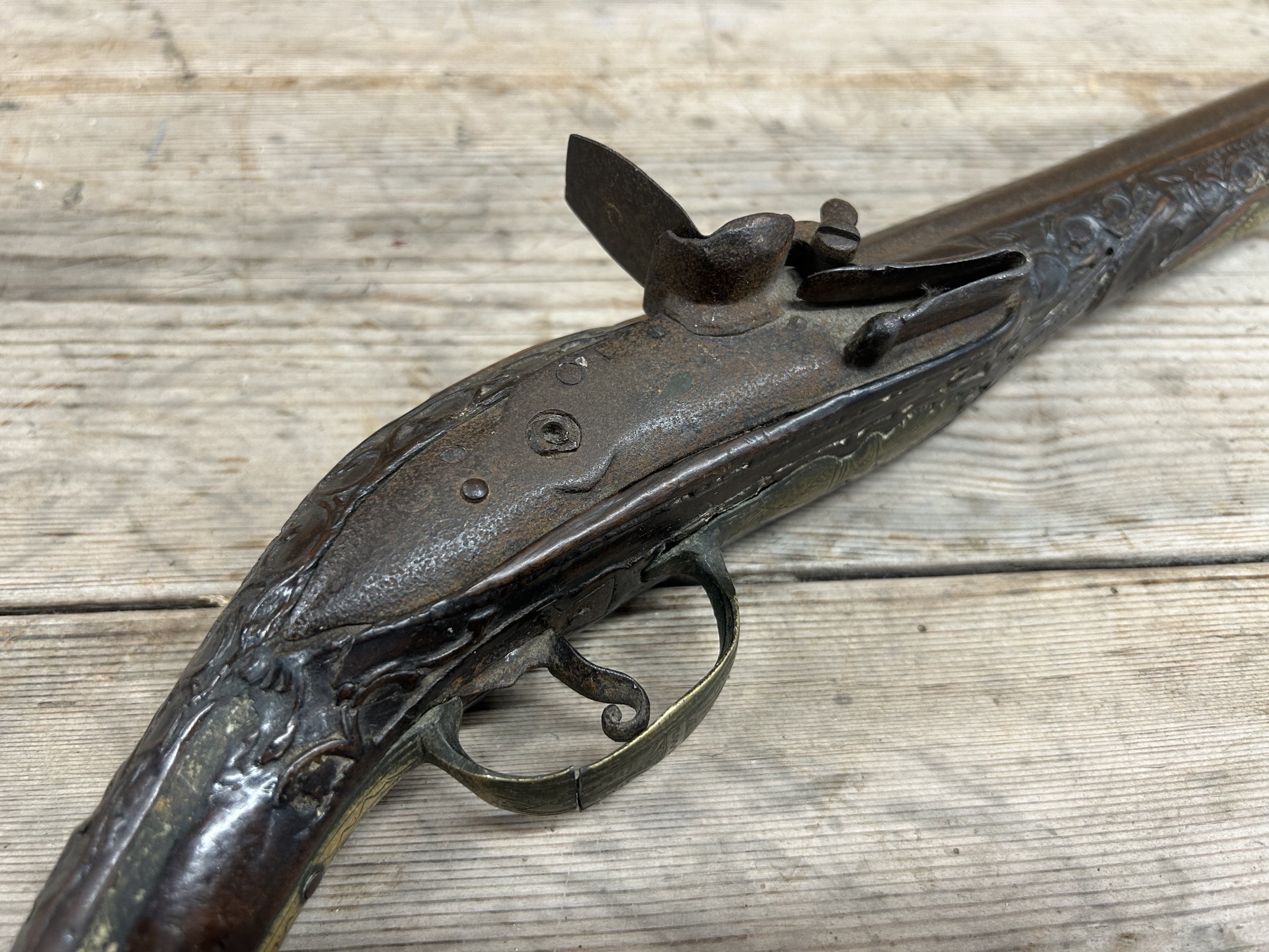 Early carved wood and brass flintlock pistol, having intricate scrolled ...