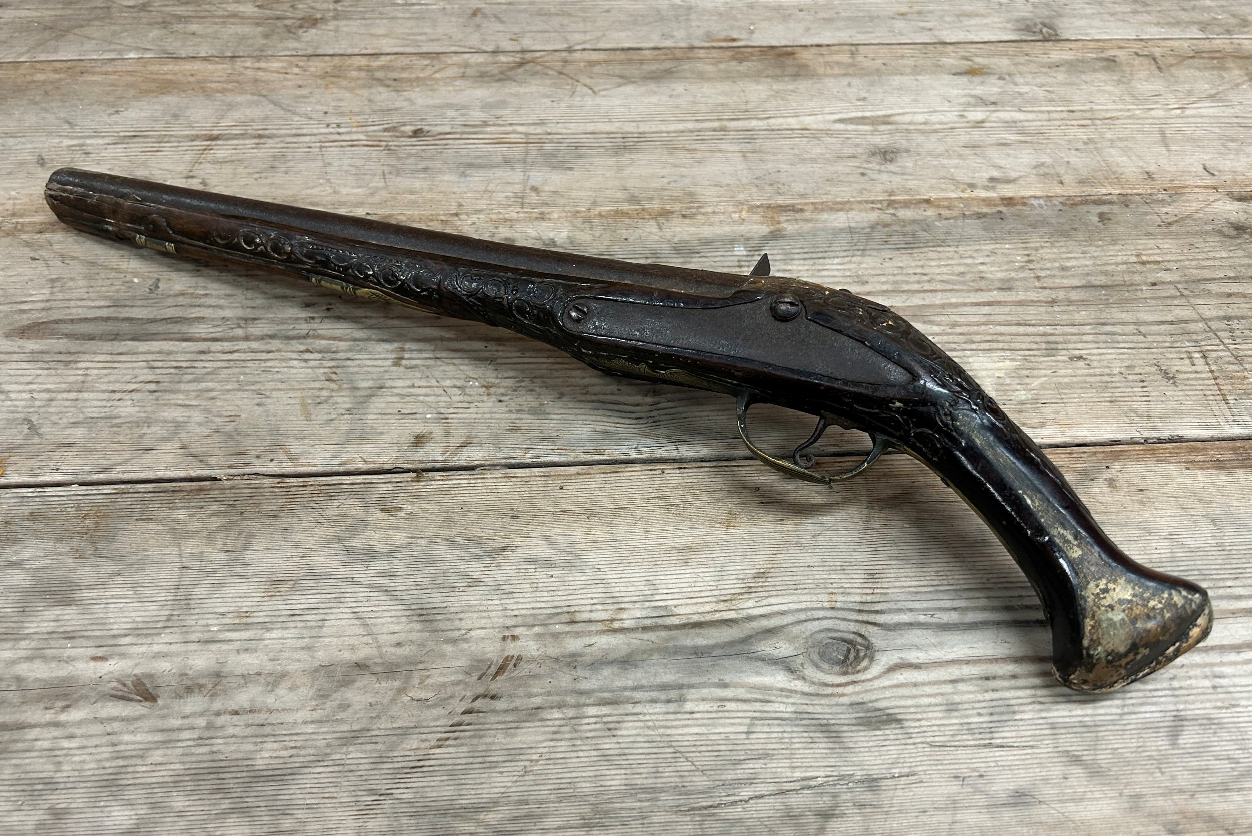 Early carved wood and brass flintlock pistol, having intricate scrolled ...