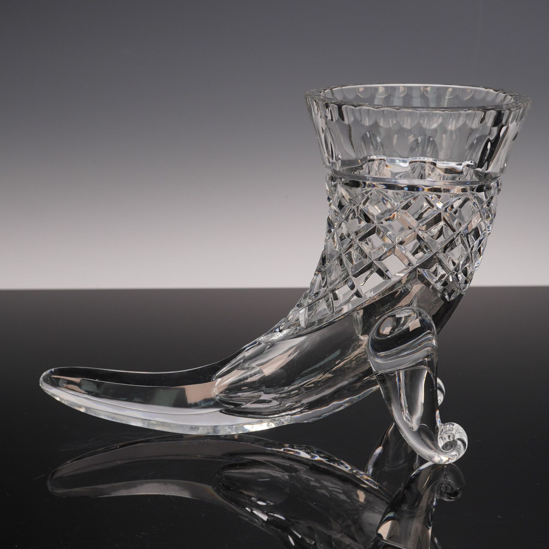 A finely crafted cut crystal cornucopia vase, featuring a flared rim ...