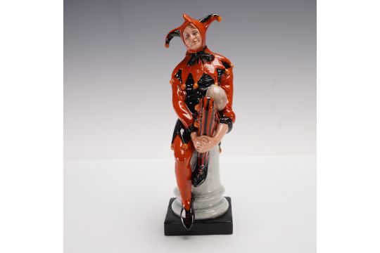 Featuring a seated court jester dressed in a red and black costume with ...