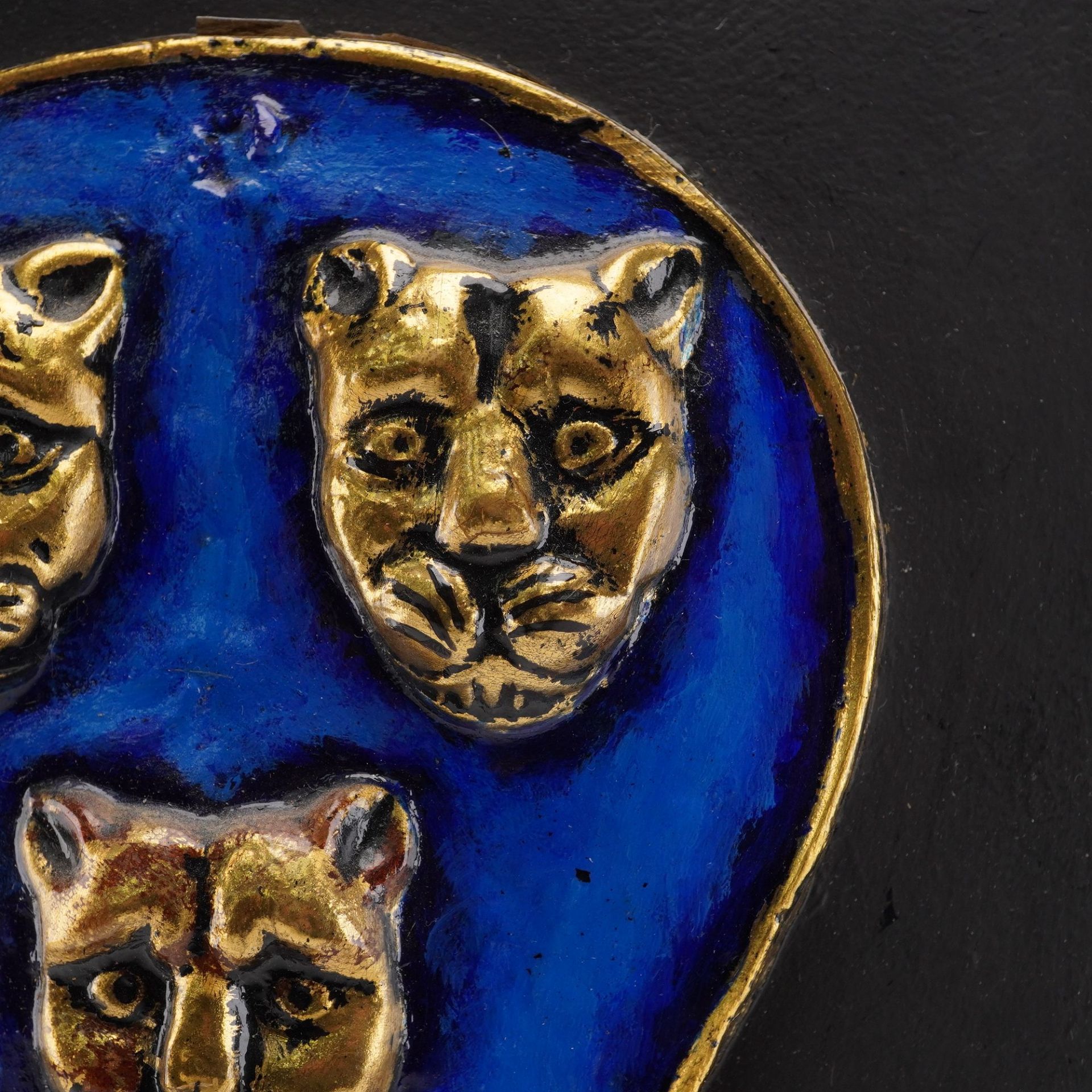 This plaque shows three raised gold leopard heads on a deep blue shield ...