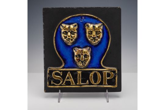 This plaque shows three raised gold leopard heads on a deep blue shield ...