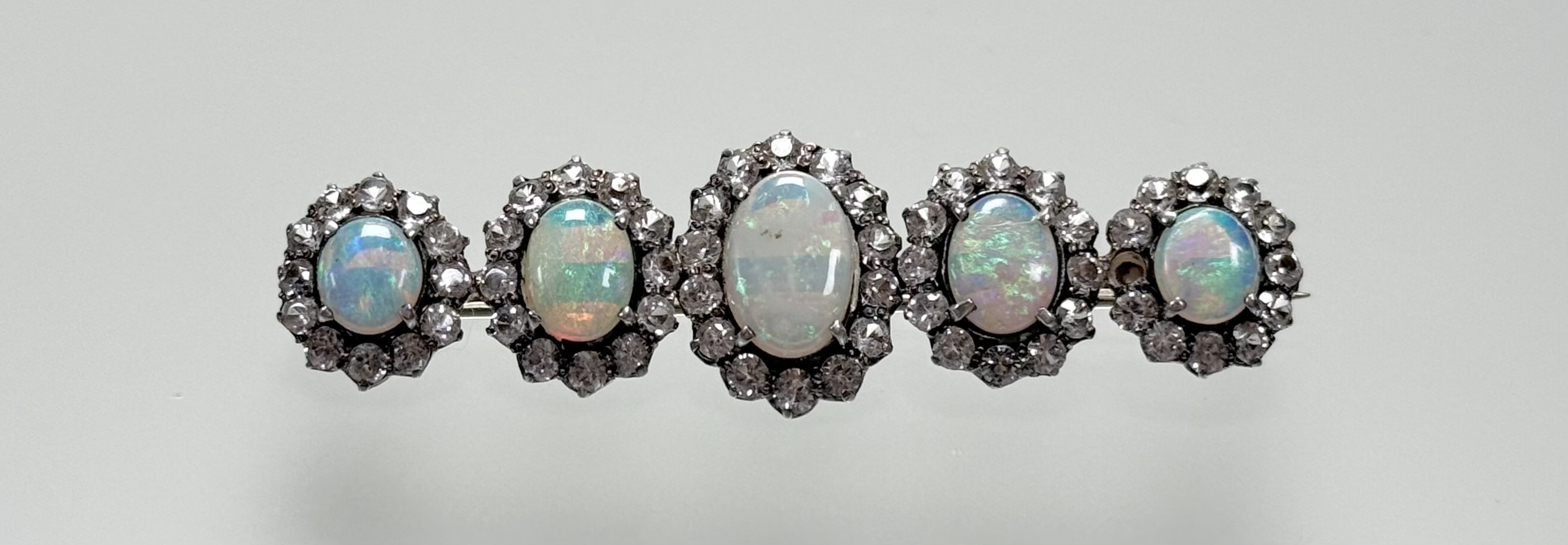 A 9ct gold bar brooch set five graduated fire opals within a surround ...