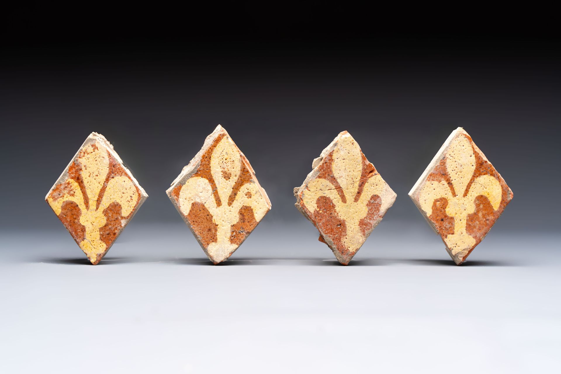 Four medieval slip-decorated 'Fleur-de-Lys' tiles, France, 15/16th C ...