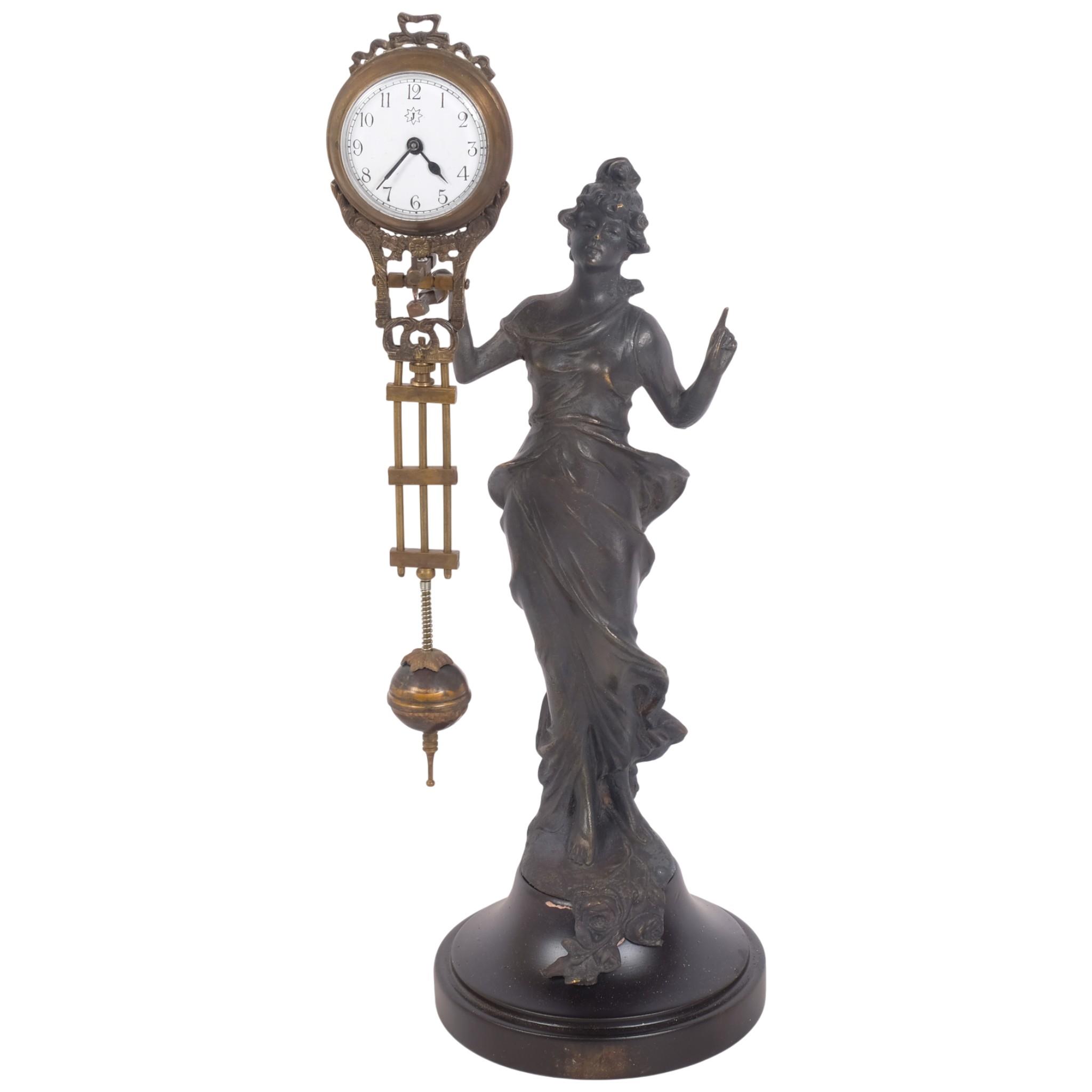 A reproduction bronze Art Nouveau style lady mystery clock, on turned ...
