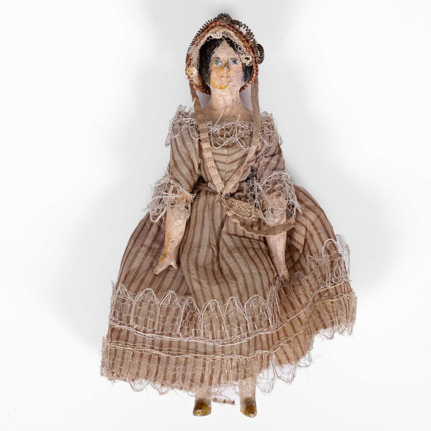 A German 'alien' head doll, circa 1845-50, wearing original striped ...