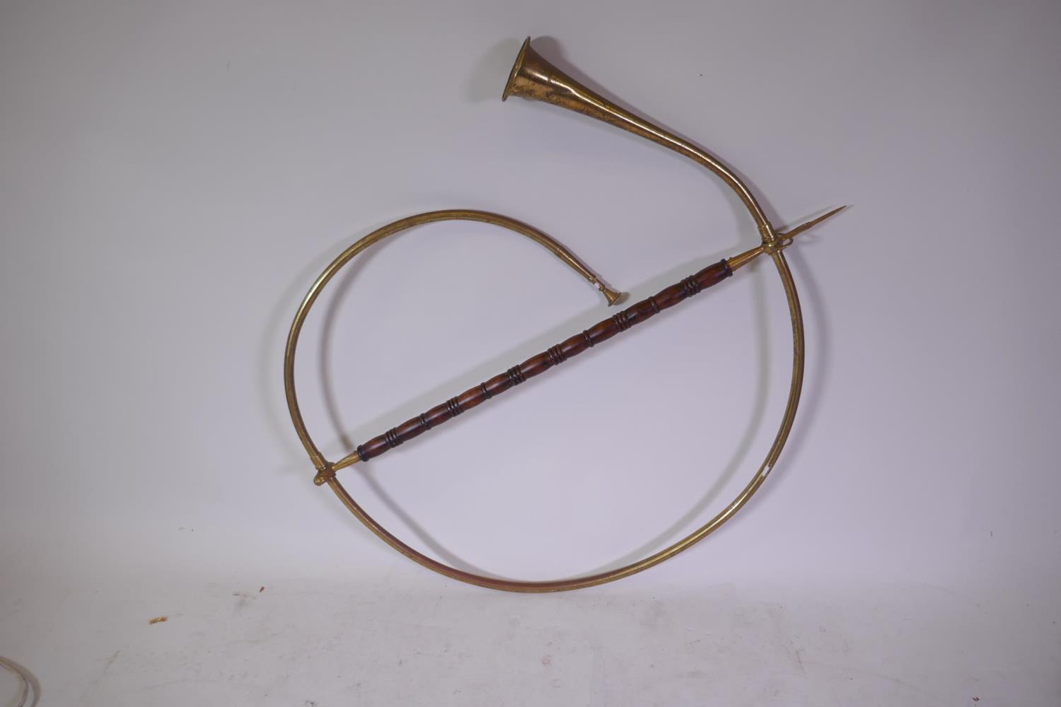 Two Roman cornu brass horns, 104cm high