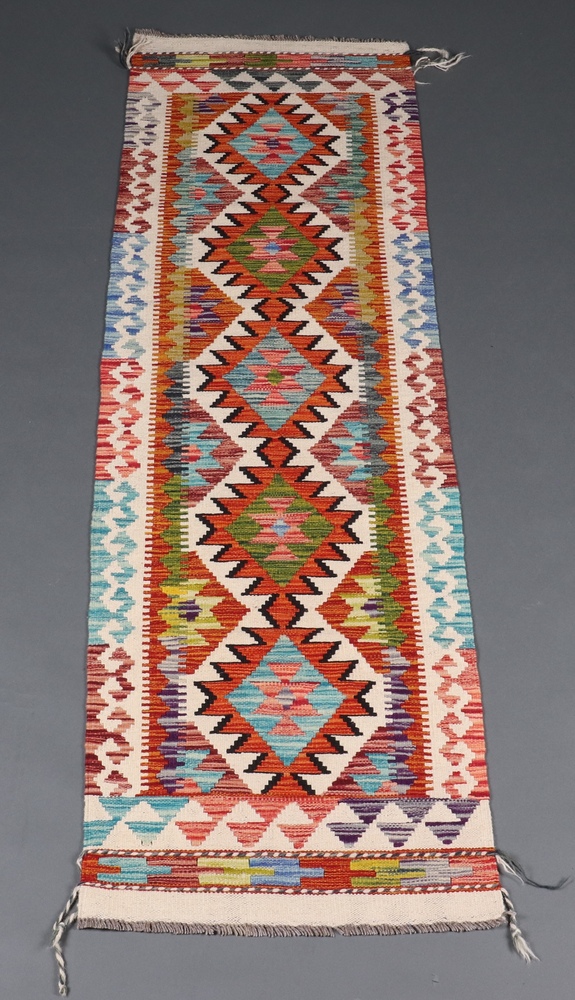 A cream, orange, green and turquoise ground Chobi Kilim runner with 5 ...