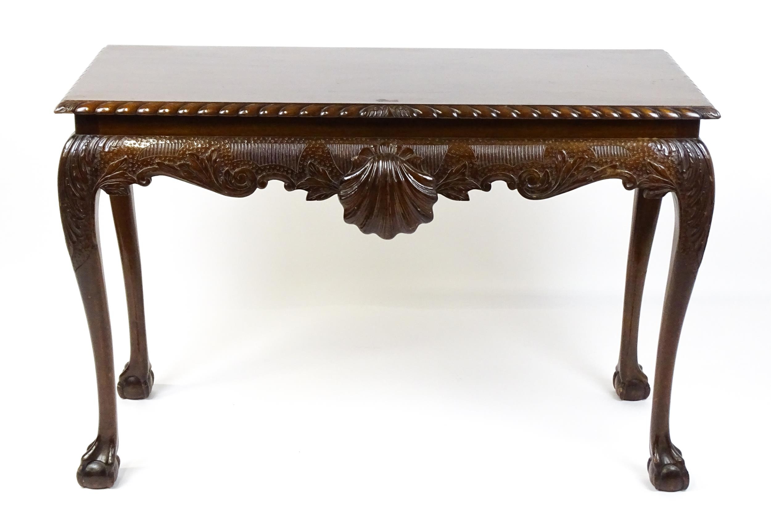 An antique Irish console table with a gadrooned top edge above a floral ...