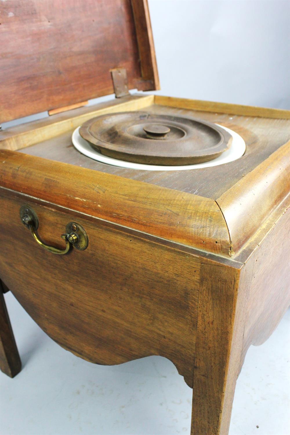 A George III mahogany commode, the hinged lid revealing an interior ...