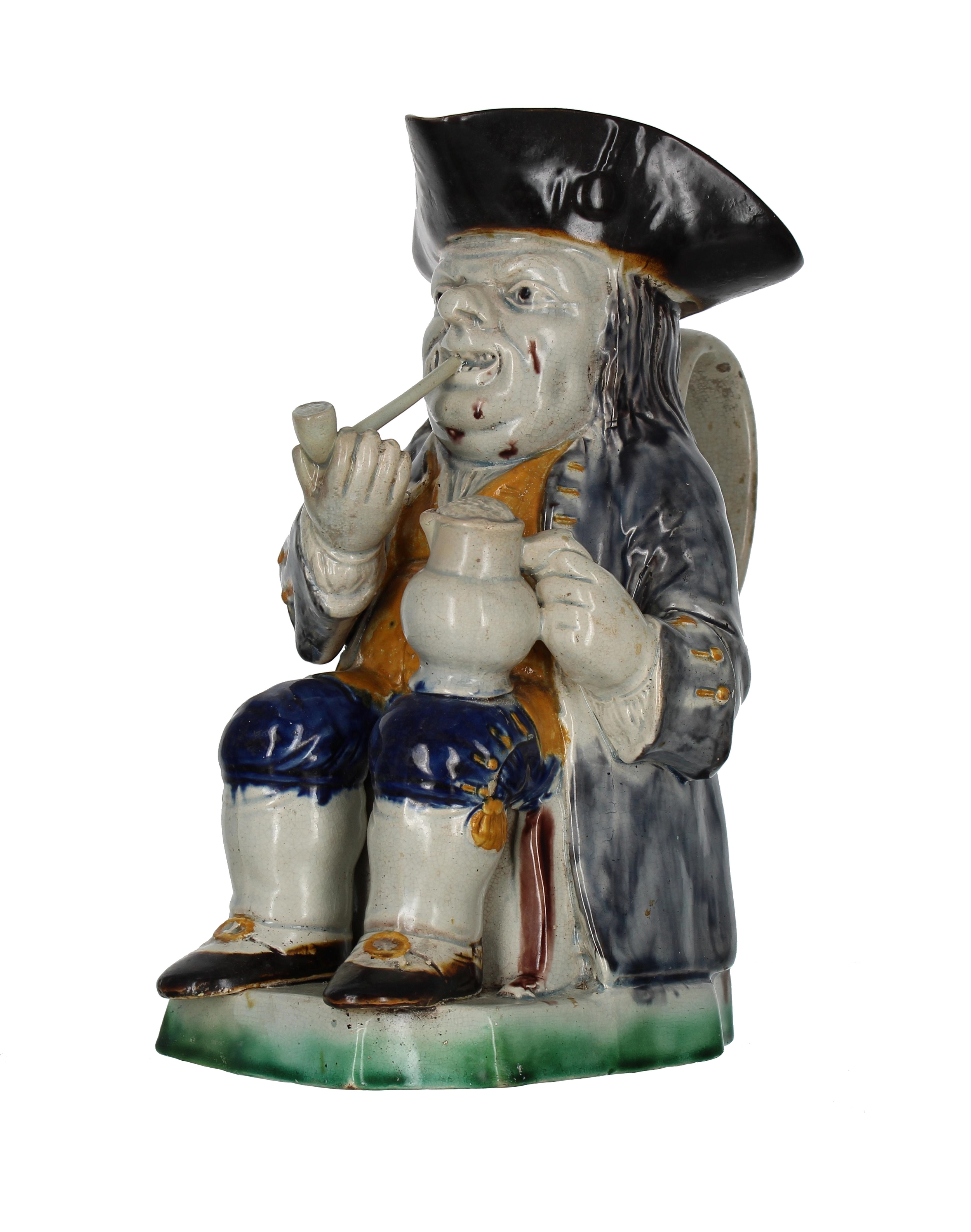 Early 19th century pearlware pottery Toby jug, modelled holding a ...