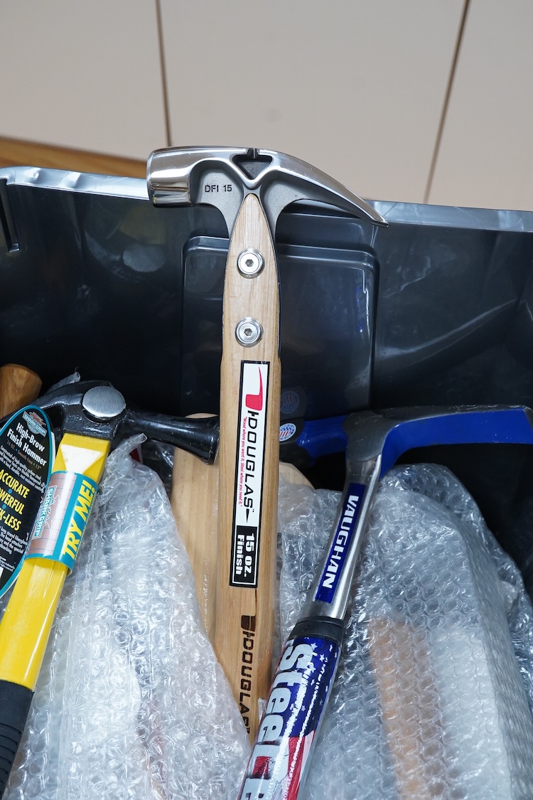 A collection of heavy duty hammers, framing hammers, and axes ...