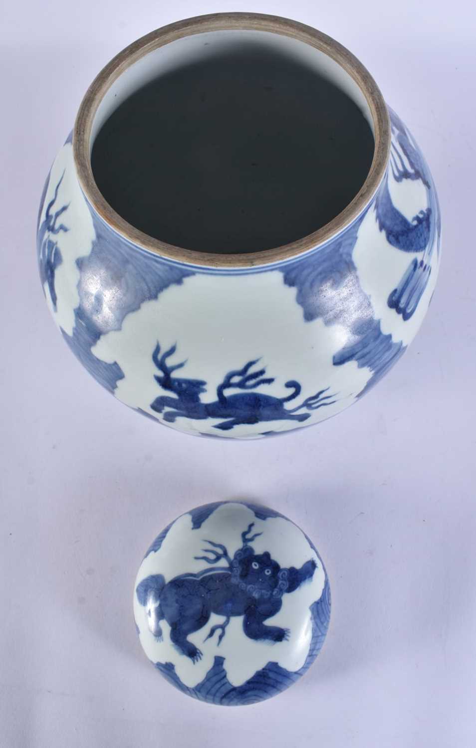A LARGE CHINESE BLUE AND WHITE JAR AND COVER painted with beasts. 33 cm ...