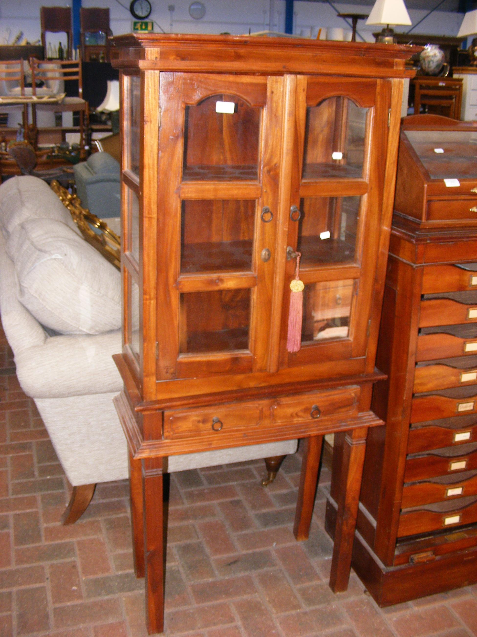 A modern two door display cabinet on stand