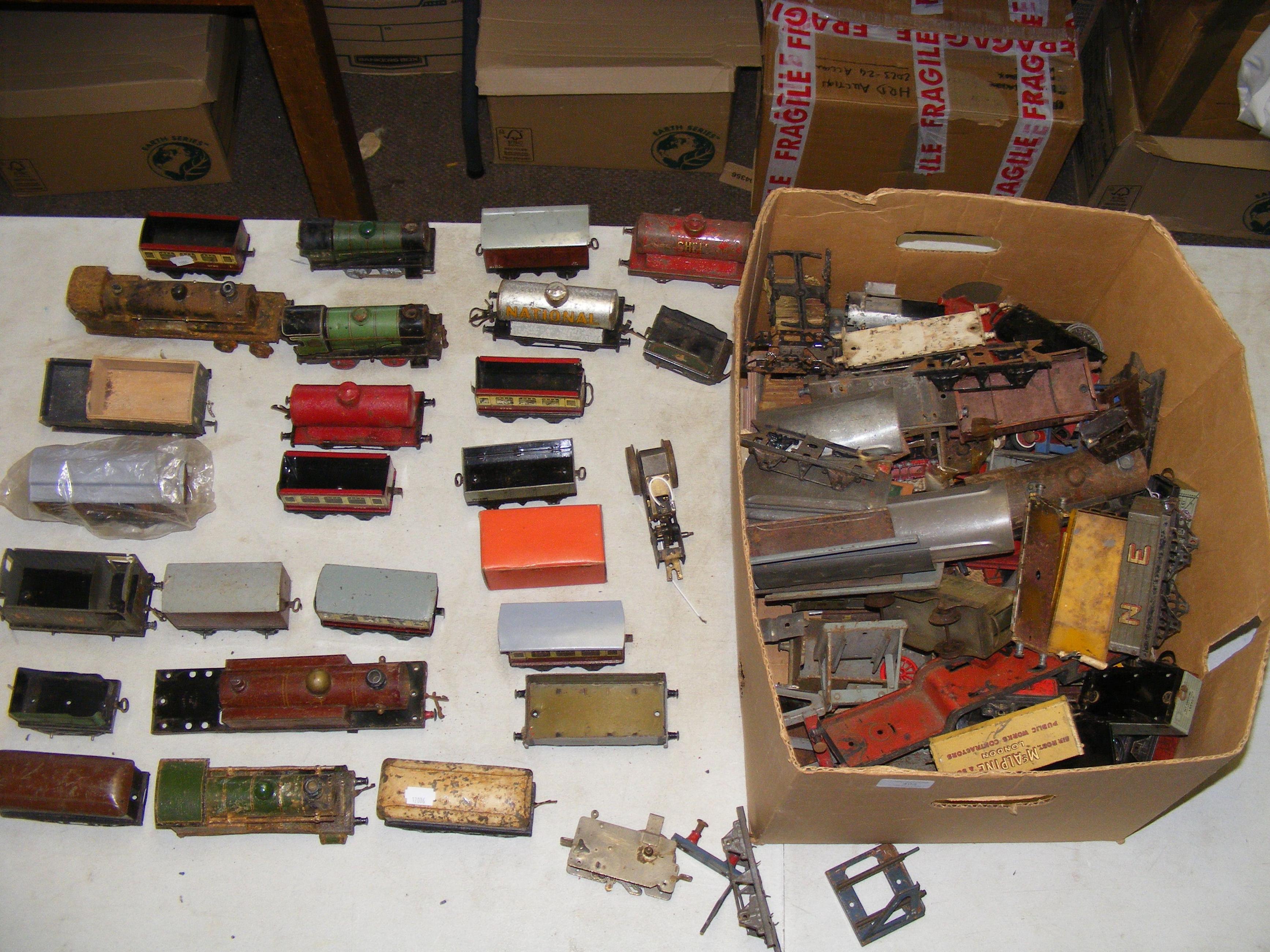 A box of 0 gauge railway items, including locomotives and carriages