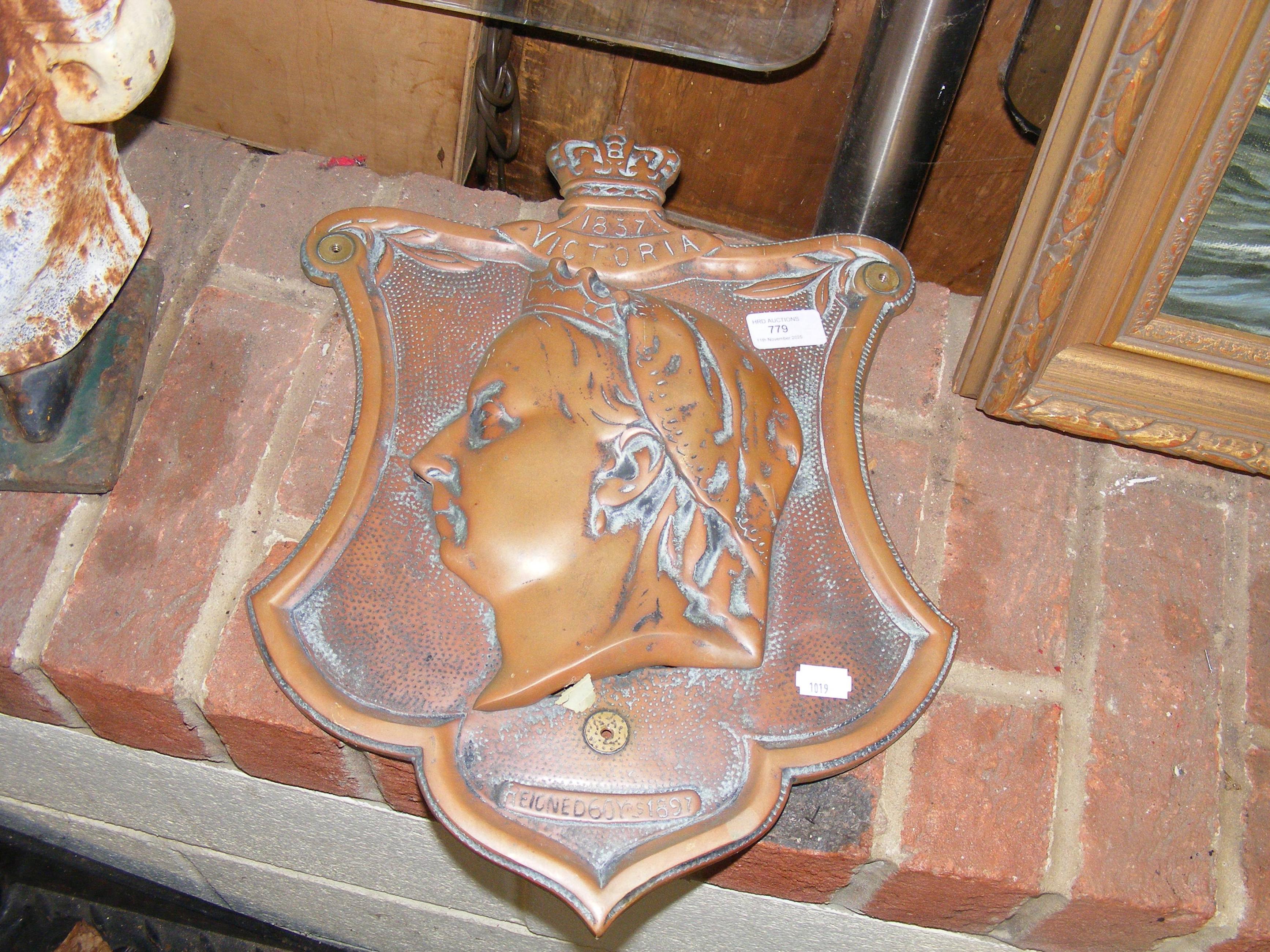A copper wall plaque bearing profile of Queen Victoria