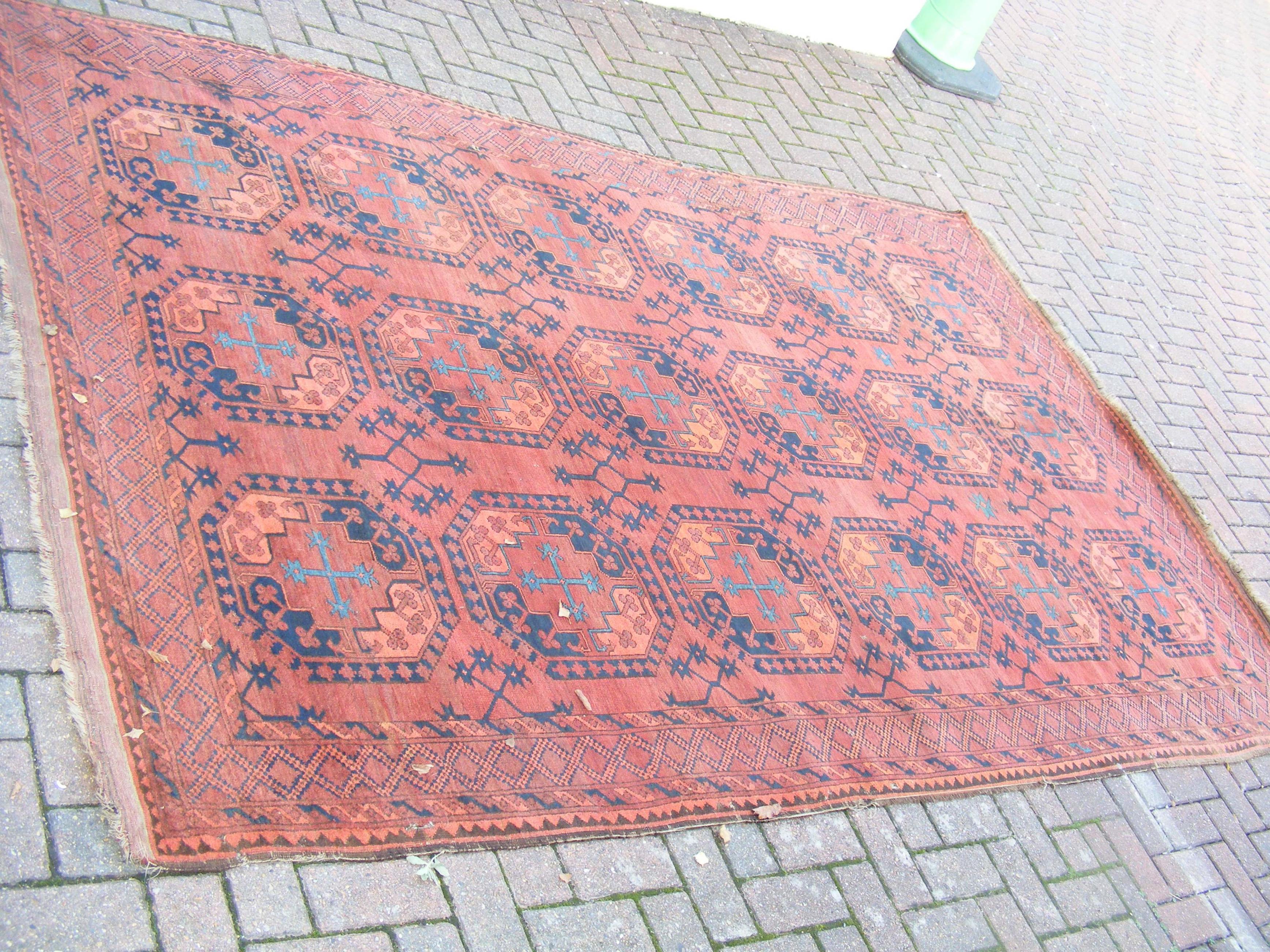 A Middle Eastern carpet with geometric border and red ground - 315cm x ...