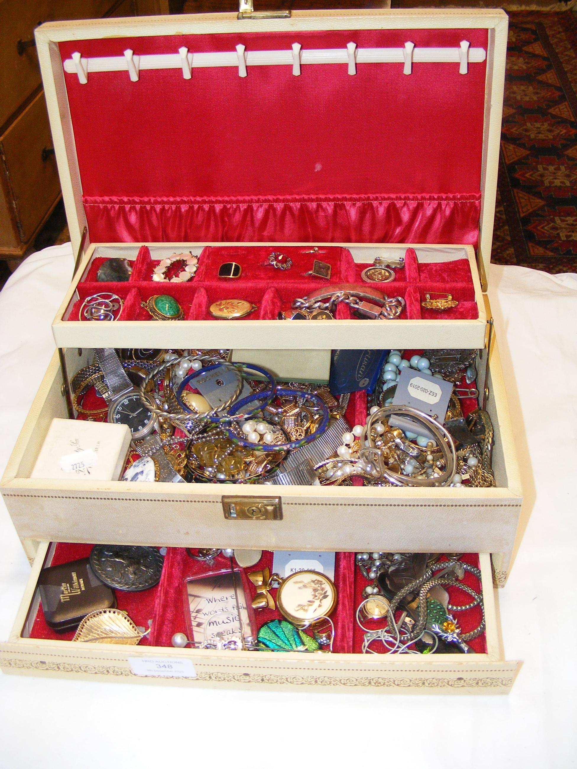 A jewellery box containing costume jewellery including necklaces etc.