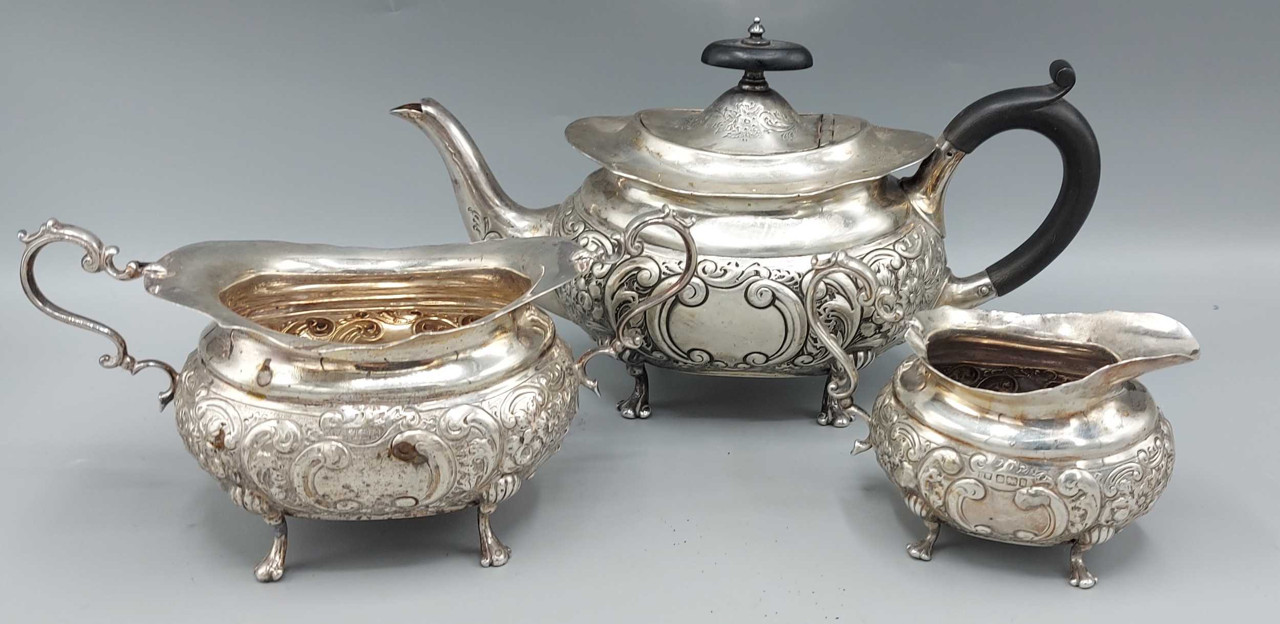 An Edwardian silver three piece tea service comprising teapot, sucrier ...