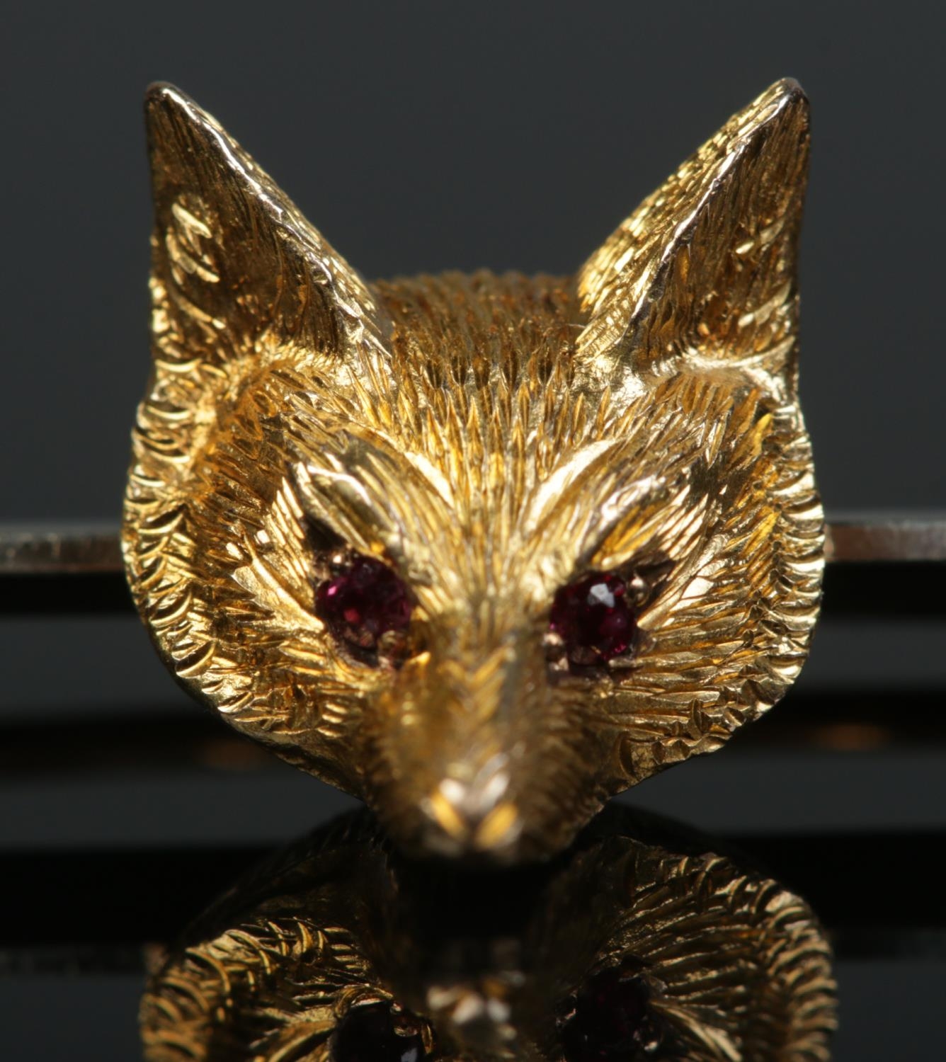 A 9ct white and yellow gold fox head bar brooch. With ruby inset eyes ...