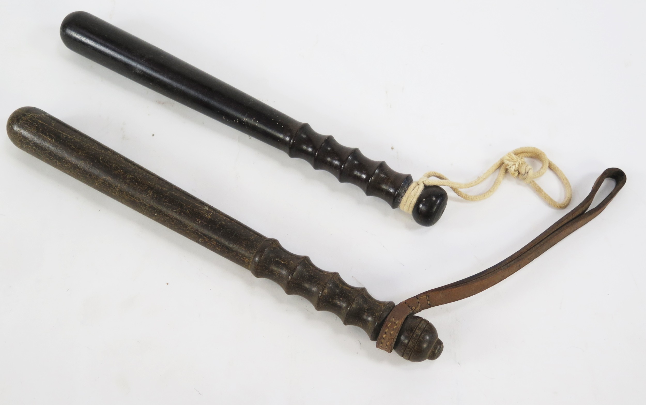 Two turned wooden truncheons, with ribbed grips, 38cm and 40cm long (2).