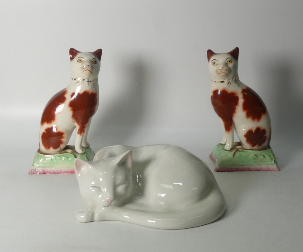 A pair of reproduction Staffordshire seated cat figures, together with ...
