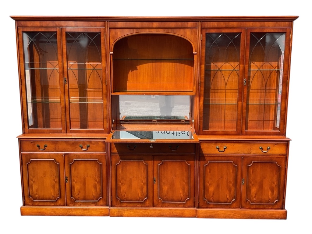 A Georgian style yew cabinet with moulded cornice above an arched open ...