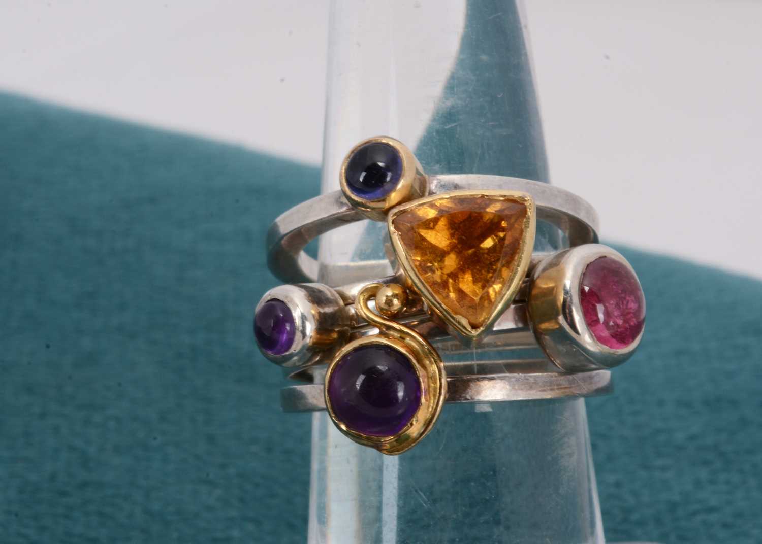A set of silver gem set stacking rings, the plain bands, set with four ...