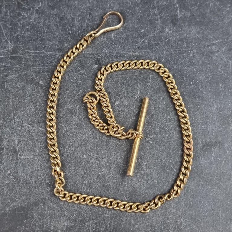 A yellow metal curb link watch chain, each link stamped, 30g, 31cm long.