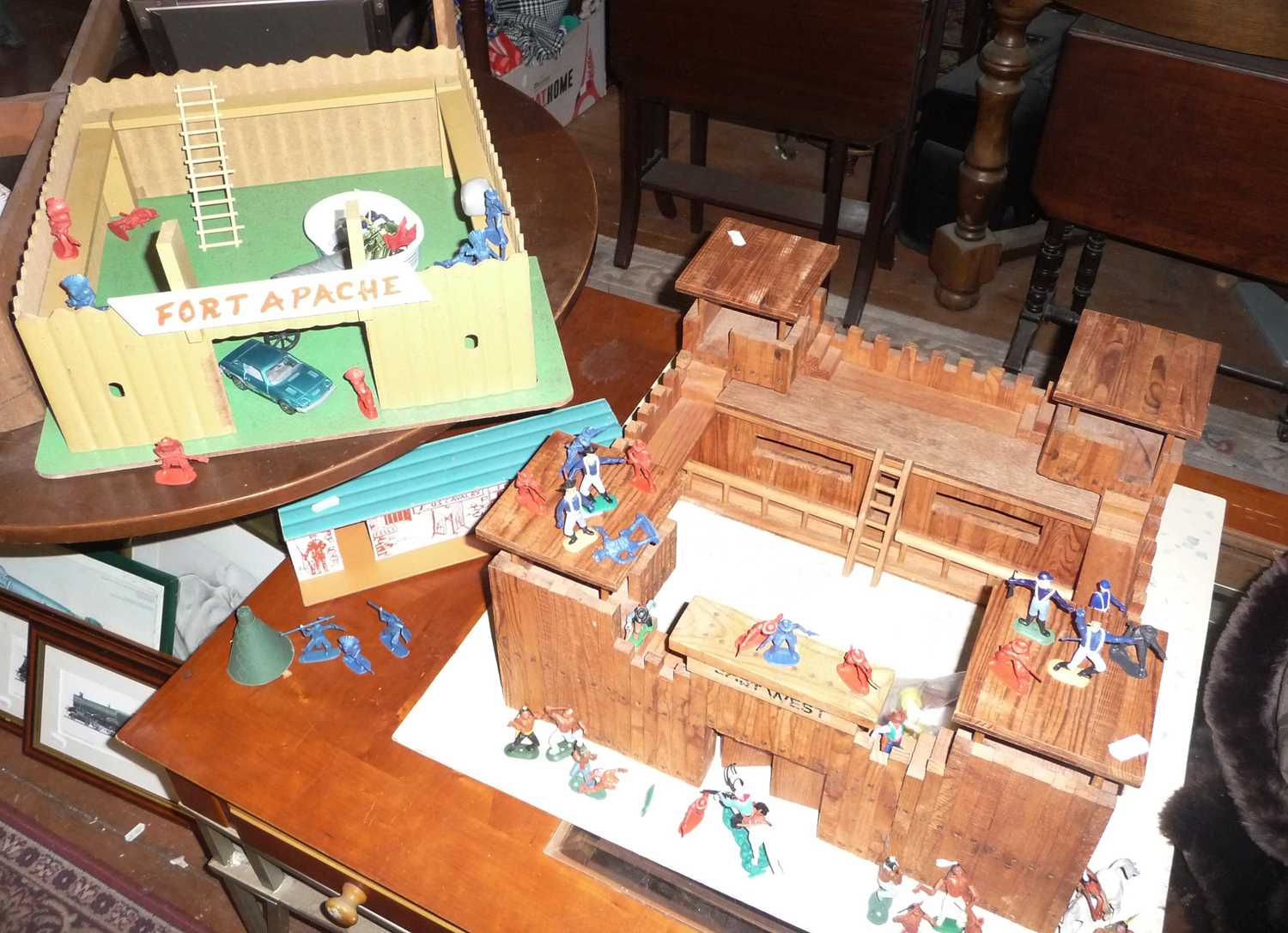 Two wooden toy forts with assorted cowboys and indians, etc