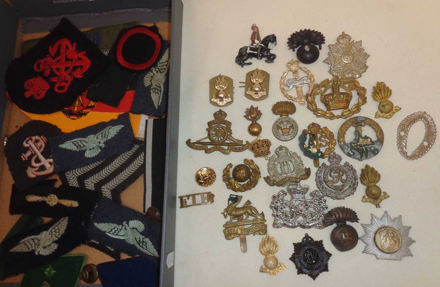 Collection of assorted army cap badges and some fabric badges