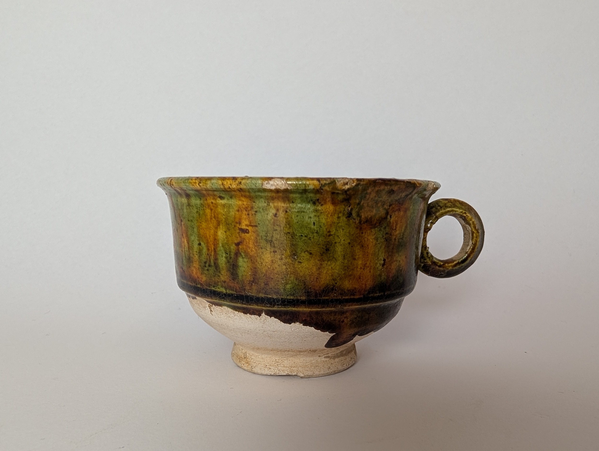 A Chinese Tang style sancai cup, the glazes covering the top half and ...