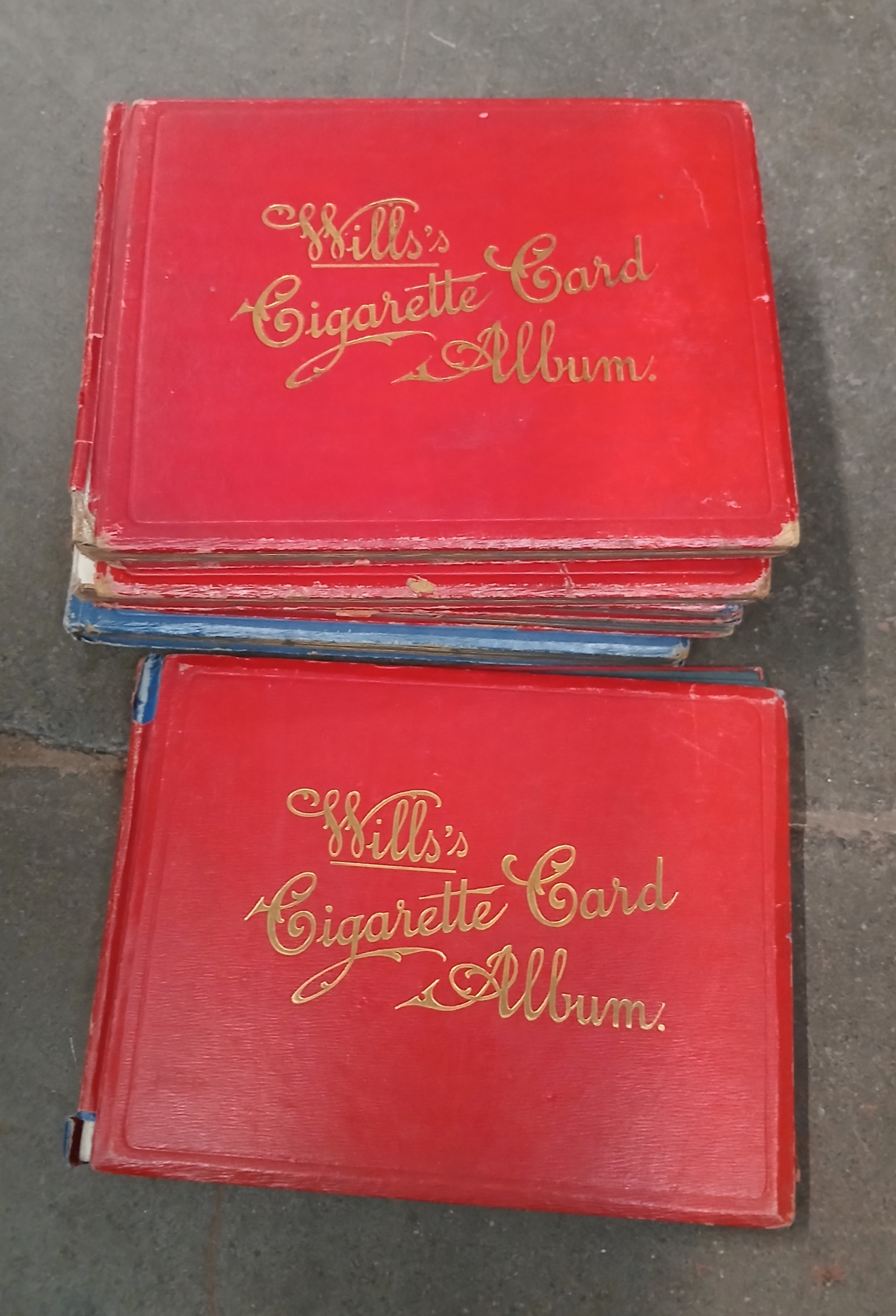 A group of six cigarette card albums and various contents.