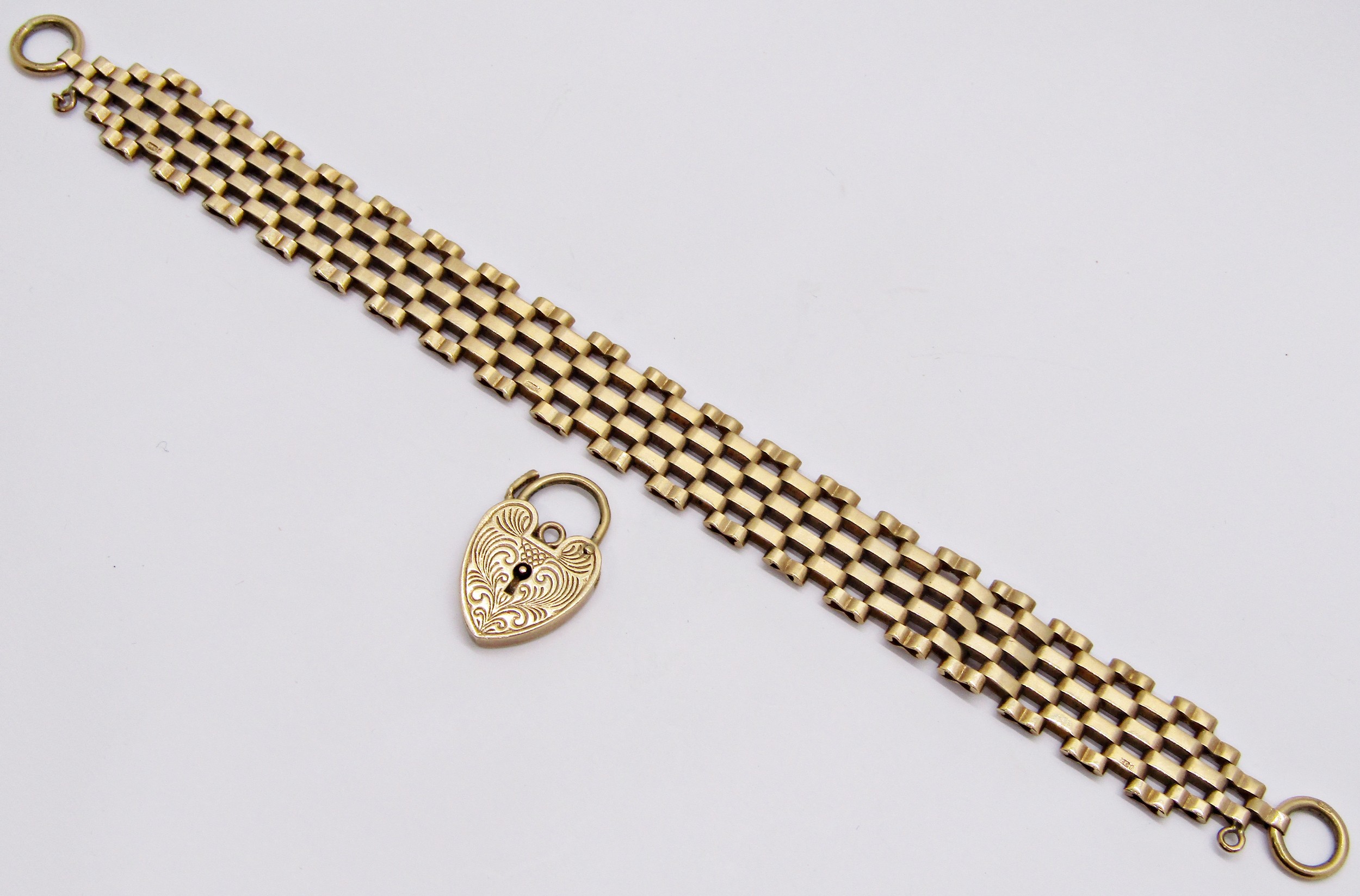 A 9ct yellow gold gate-link bracelet, with engraved heart-shaped ...