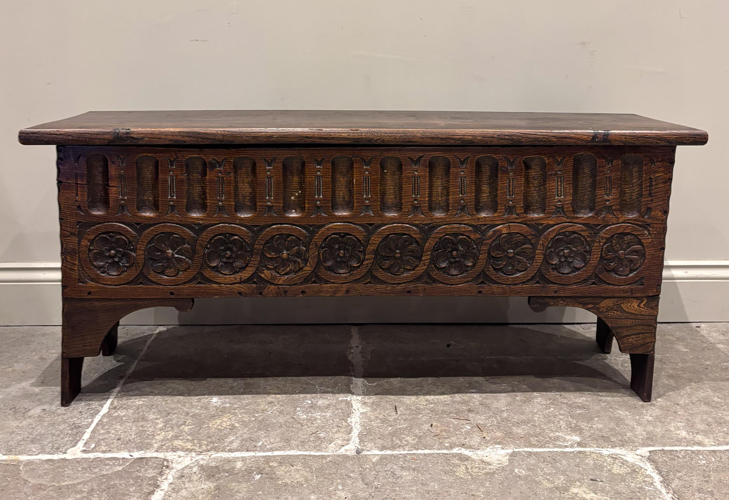 A 17th century and later oak six plank coffer, the carved front with a ...