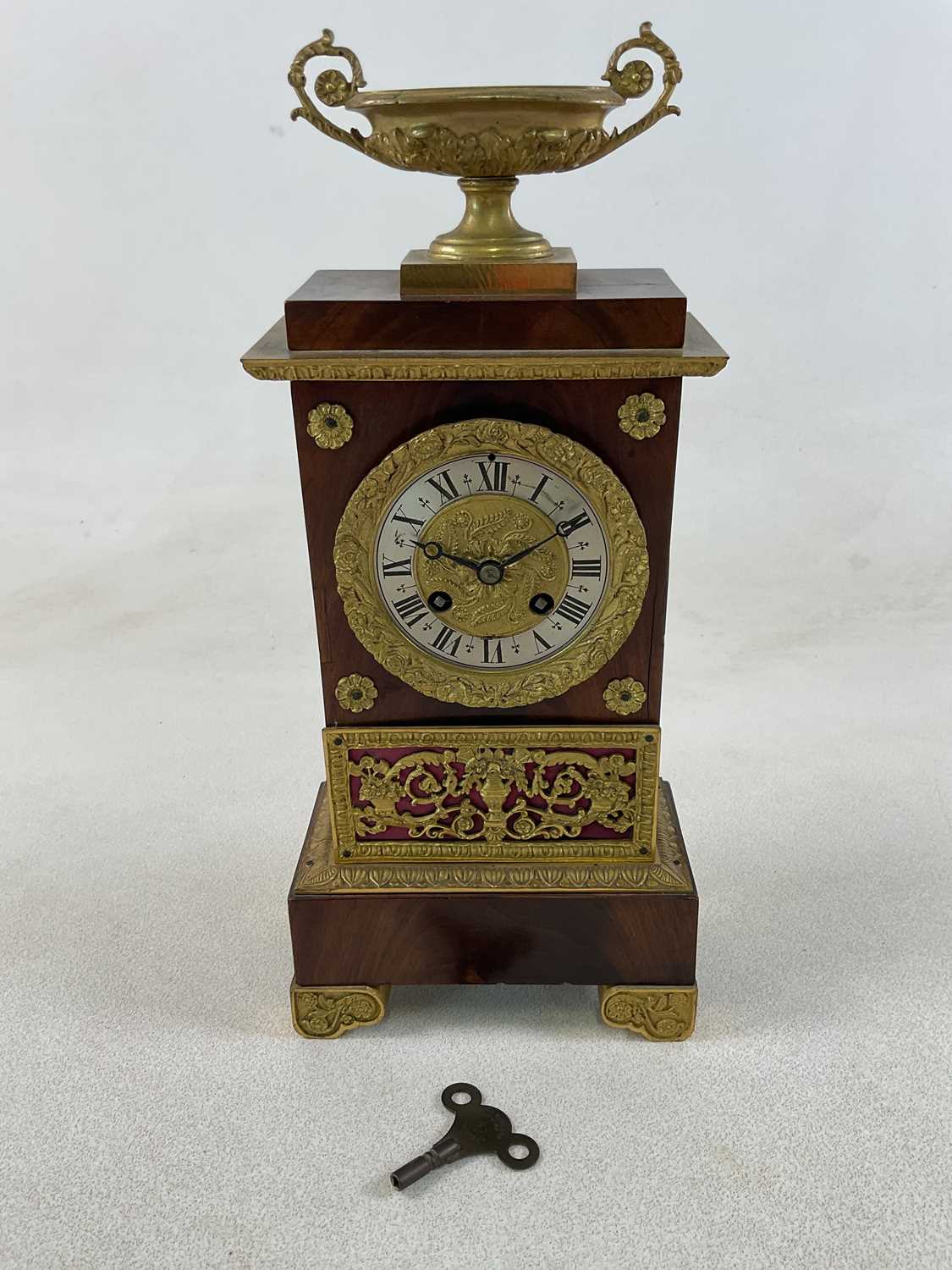 A French mahogany Empire style mantel clock with urn finial, Roman ...