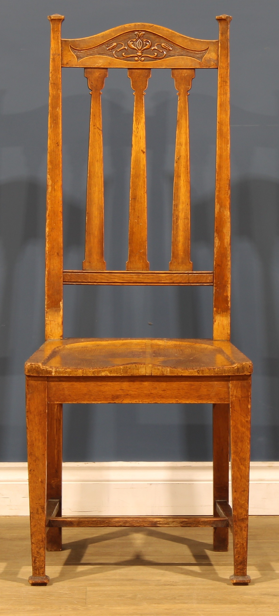 A set of twenty-four Arts & Crafts oak dining chairs, each cresting ...